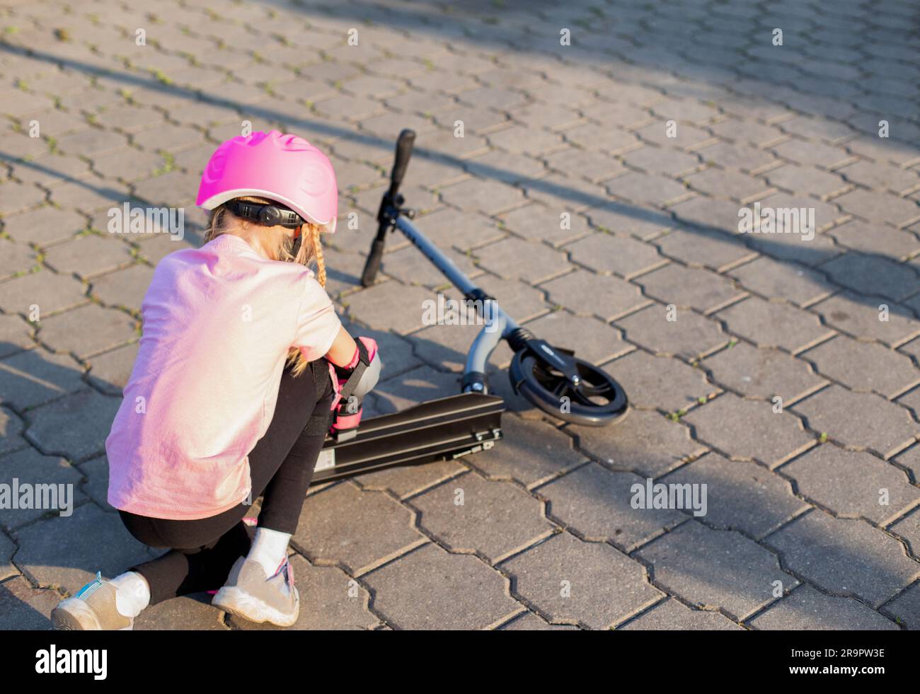 A 7-year-old girl in a pink helmet and protective gear fell off a ...