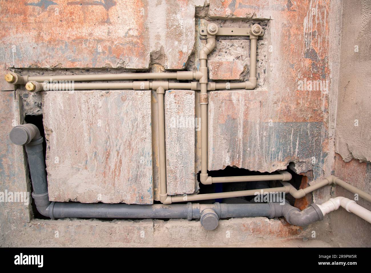 Transfer of water pipes and sewerage drain in the wall. Bathroom plumbing installation Stock ...