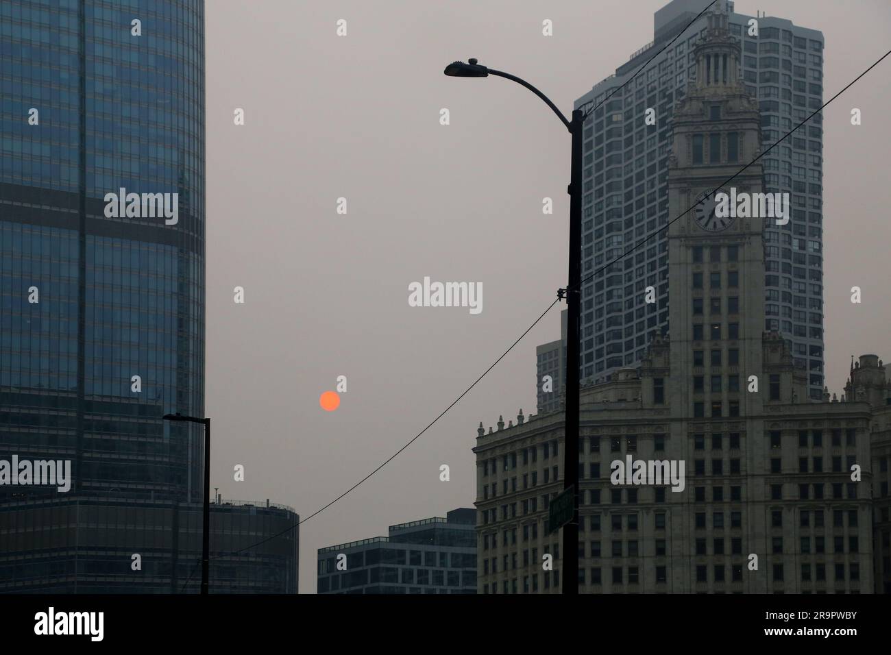 A hazy sunset from the heavy smog is seen over buildings in downtown ...