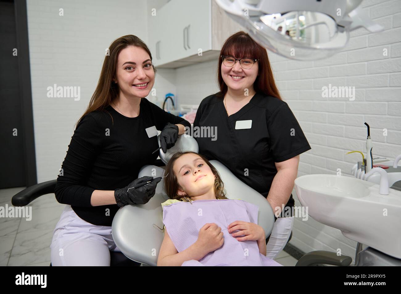 Medical staff, female dentist doctor and dental assistant smile at ...