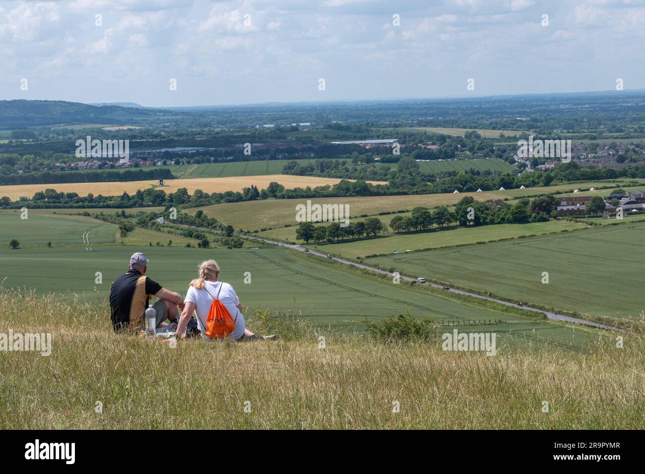 A couple sitting enjoying the view at the summit of Ivinghoe Beacon in ...