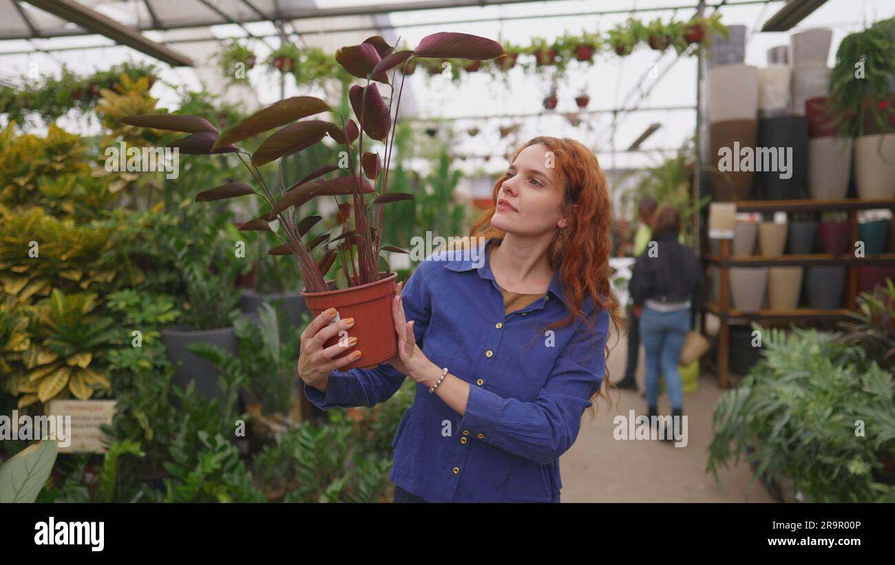 Joyful woman walking through horticulture gardening supply business ...