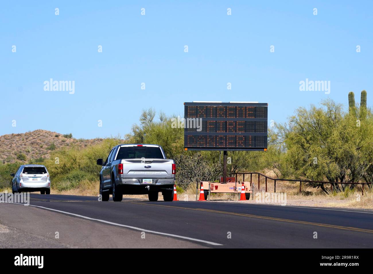 Vehicles drive past warning signs from the Diamond Fire that has burned ...