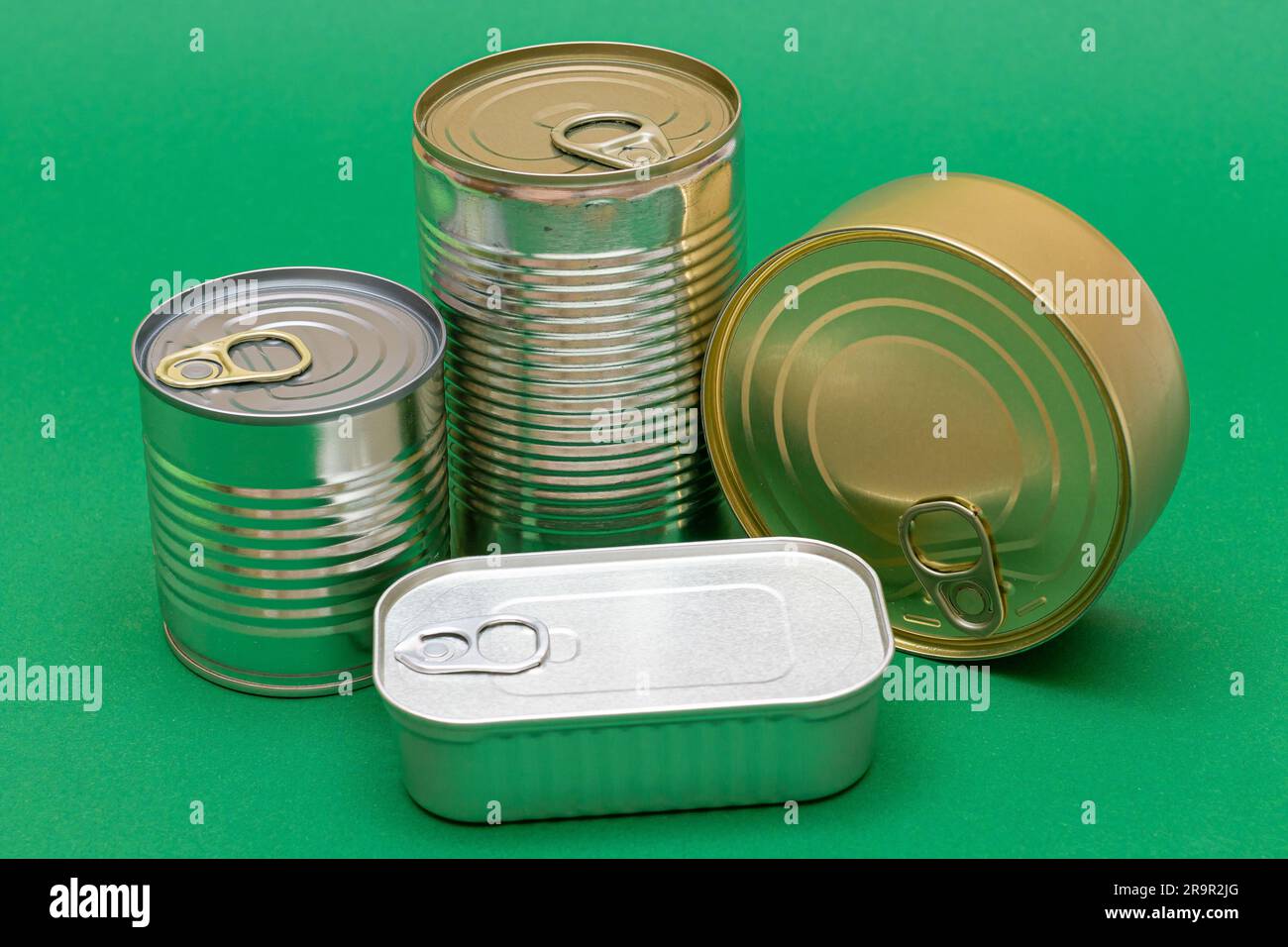 A Group of Stacked Tin Cans with Blank Edges on Green Background ...