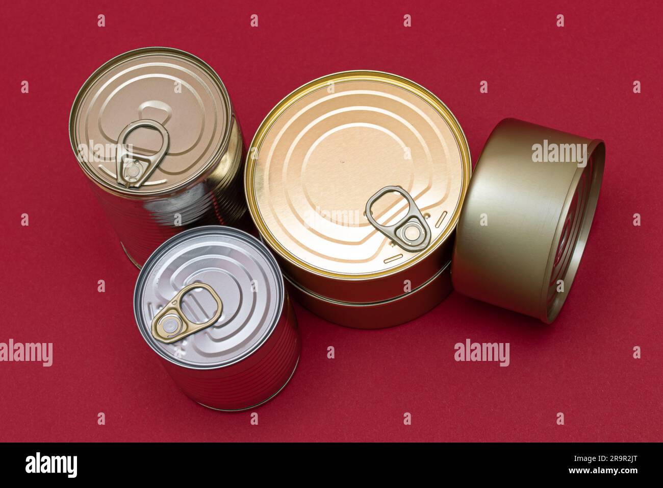 A Group of Stacked Tin Cans with Blank Edges on Red Background. Canned ...