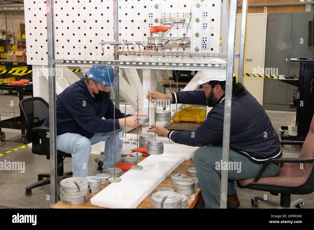 . Aaron Rumsey and Beto Hinojos carefully add weight to a 6-foot model ...