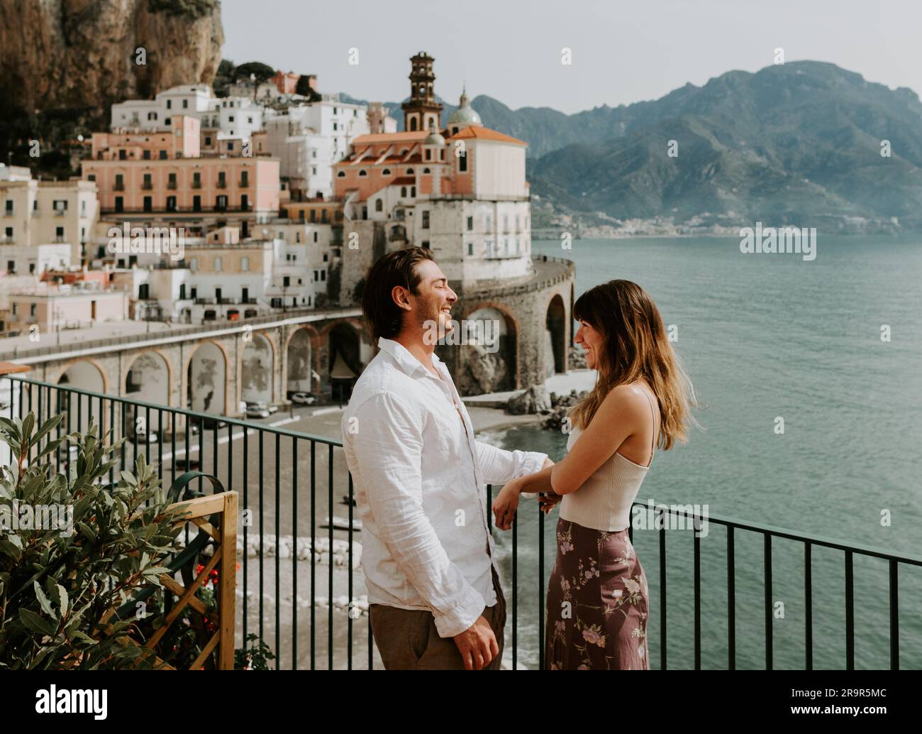 Couple laughing on balcony on the Amalfi Coast Stock Photo - Alamy