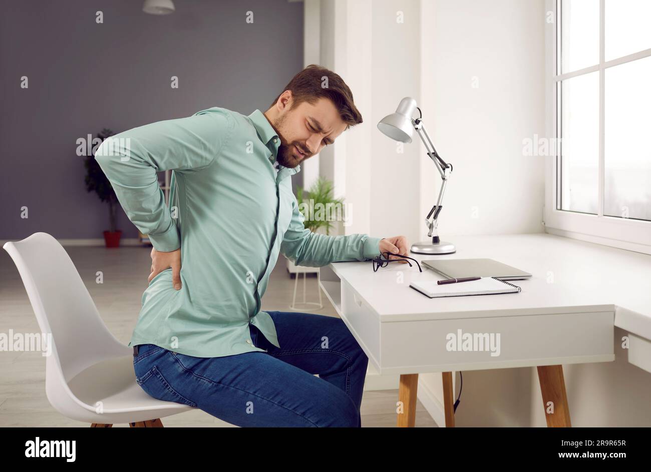 Exhausted man feeling pain in back suffering from lower lumbar backache ...