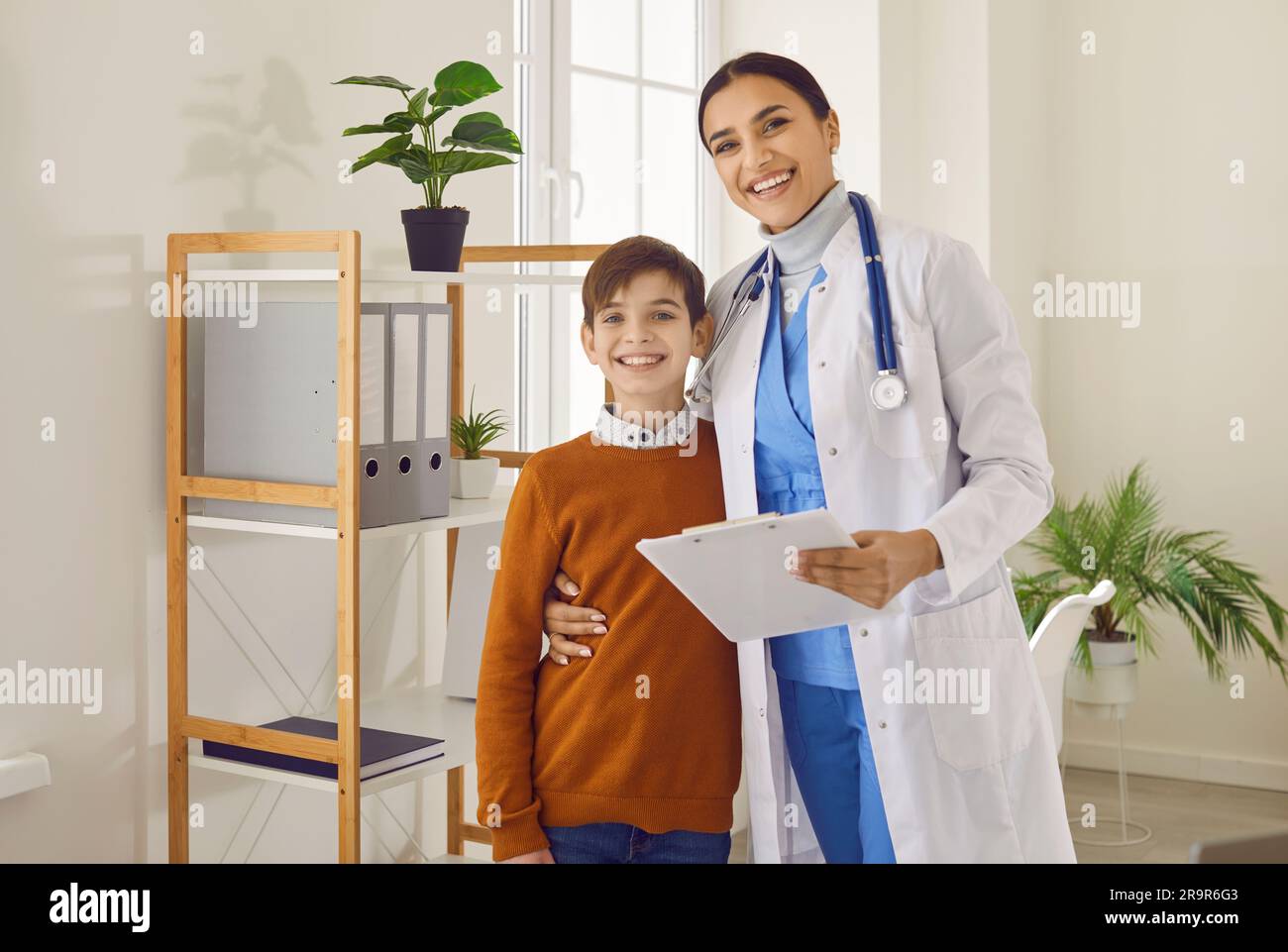 Portrait of a female friendly doctor with a child boy patient during ...