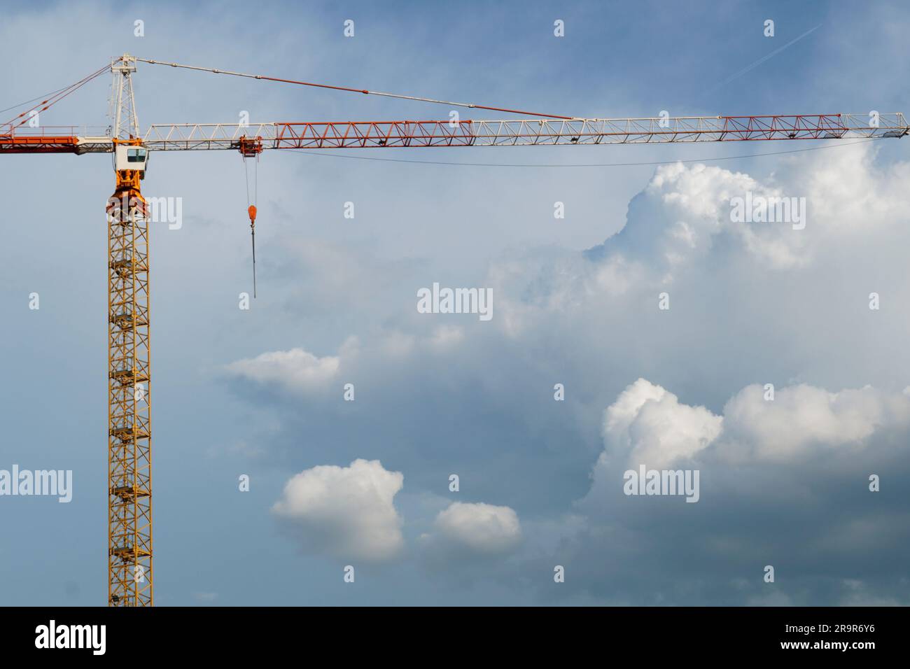 Tall metal crane on sky with cumulus clouds background Stock Photo - Alamy
