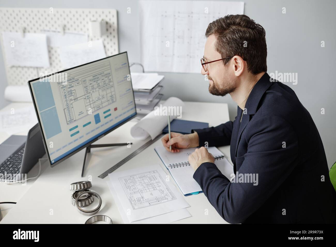 High angle portrait of bearded male engineer using computer at ...