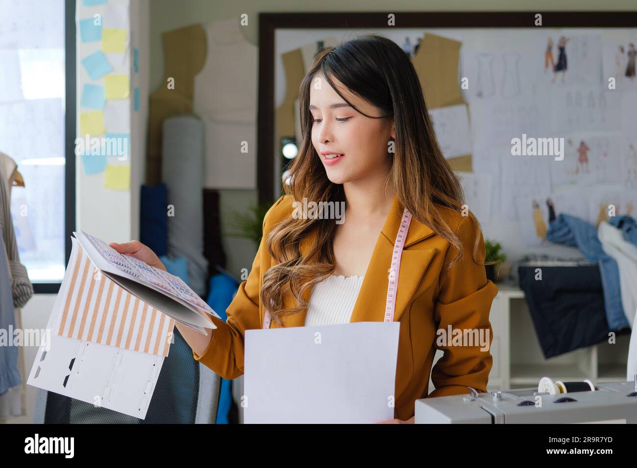 Female fashion designer woman working on her designs in workshop studio ...