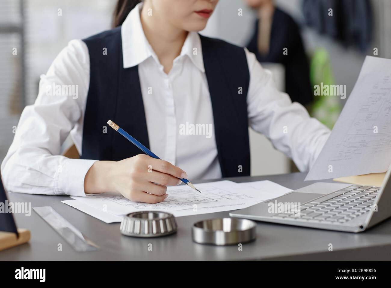 Closeup of female engineer using computer at workplace in office and ...