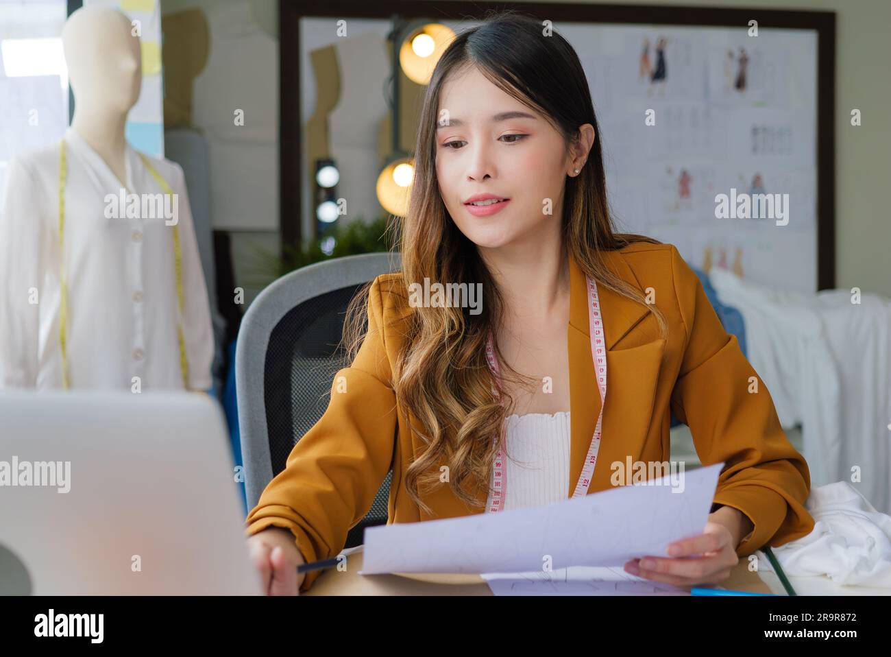 Female fashion designer woman working on her designs in workshop studio ...