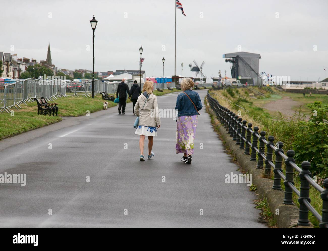 Two ladies deep in conversation as they stroll along the promenade ...