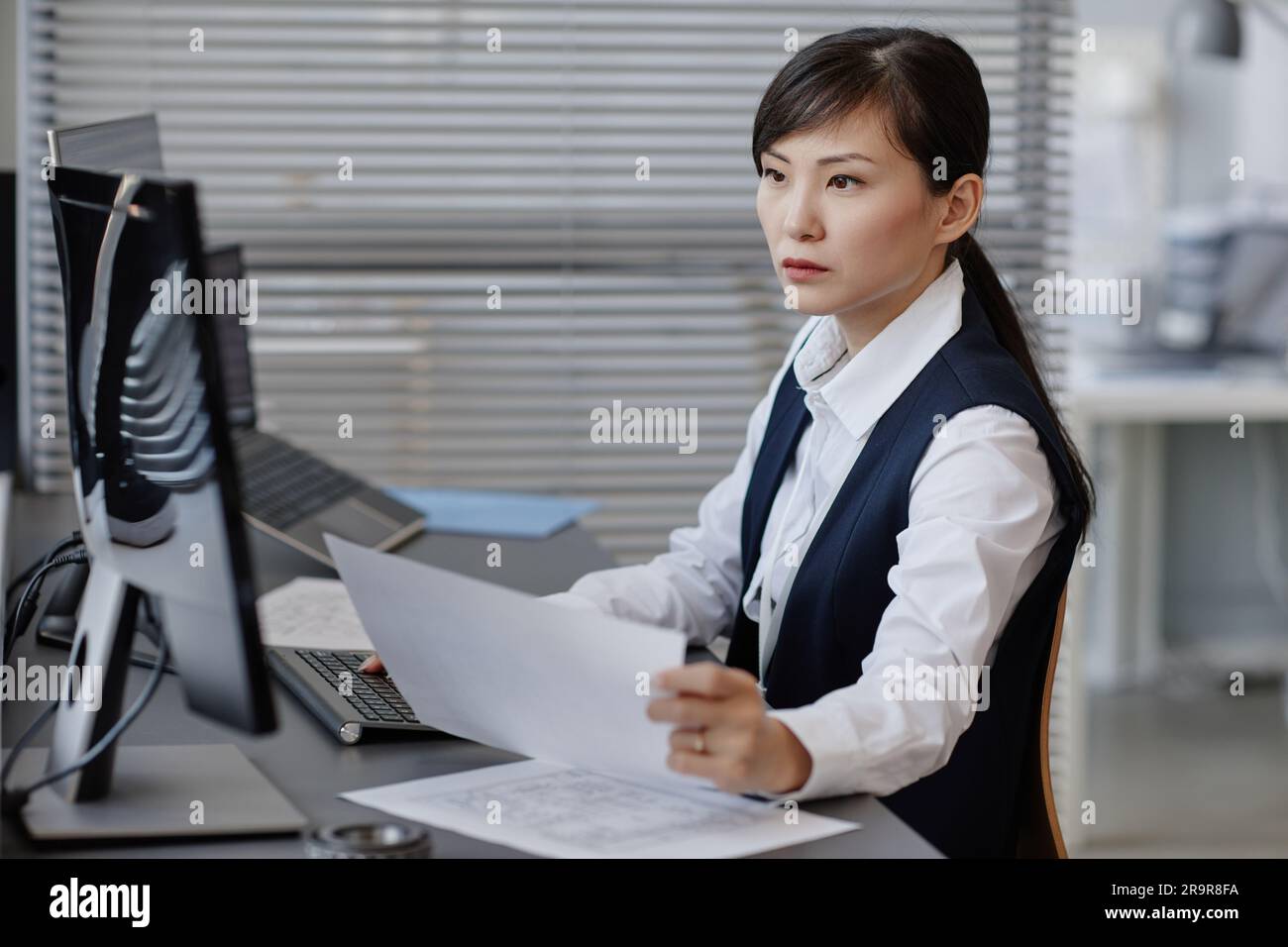 Side view portrait of Asian woman as female engineer using computer and ...