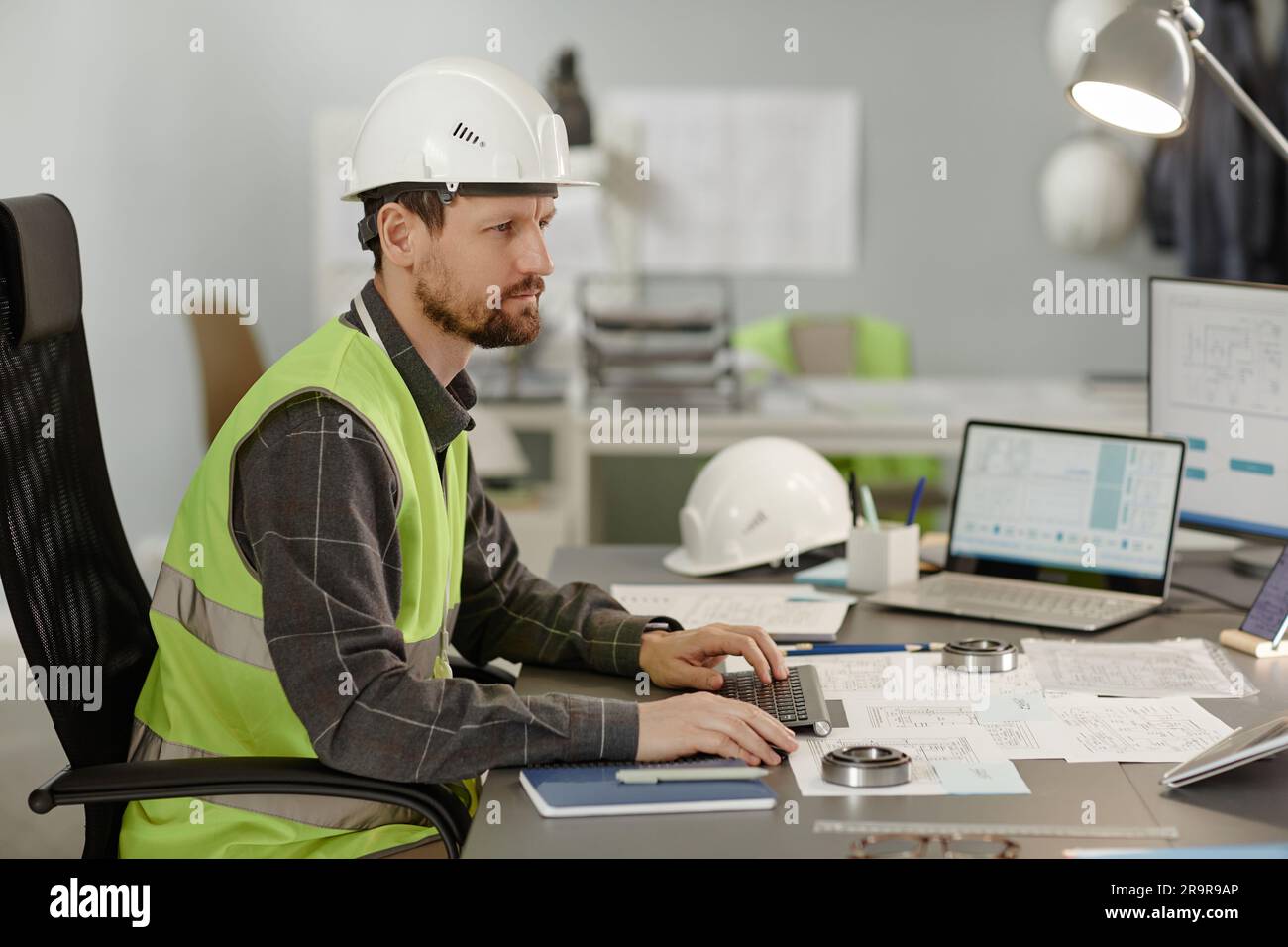 Side view portrait of bearded construction engineer wearing hardhat at ...