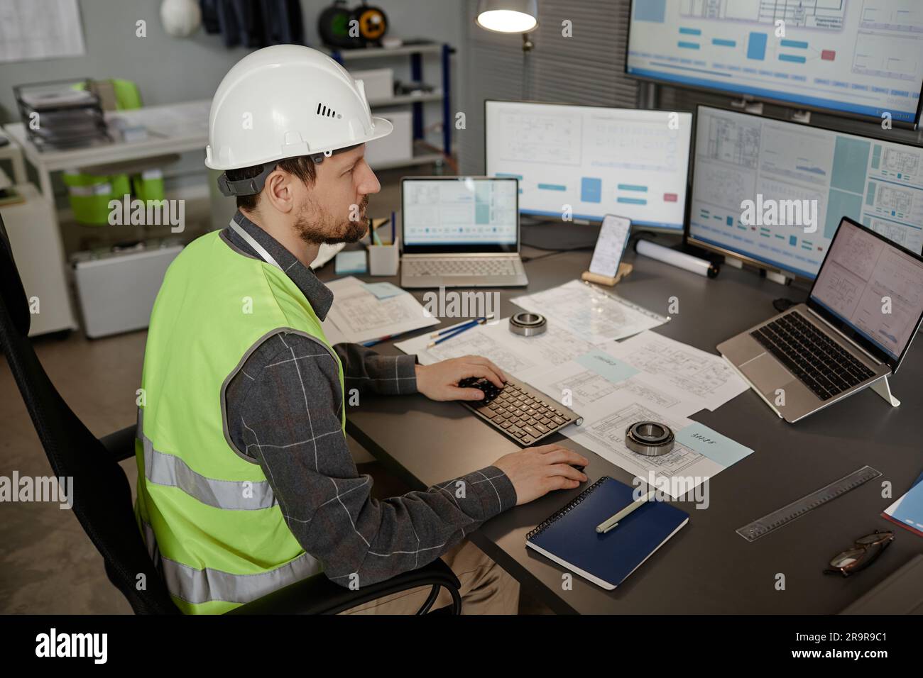 Side view portrait of bearded mechanical engineer wearing hardhat at ...