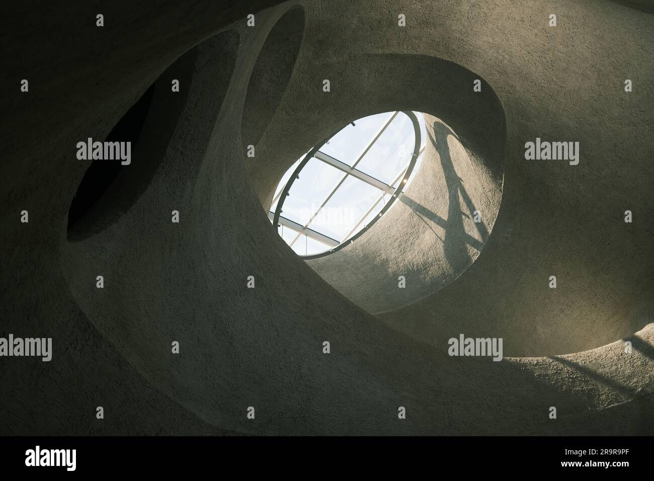 A modern building interior showcases a large circular window, providing ...
