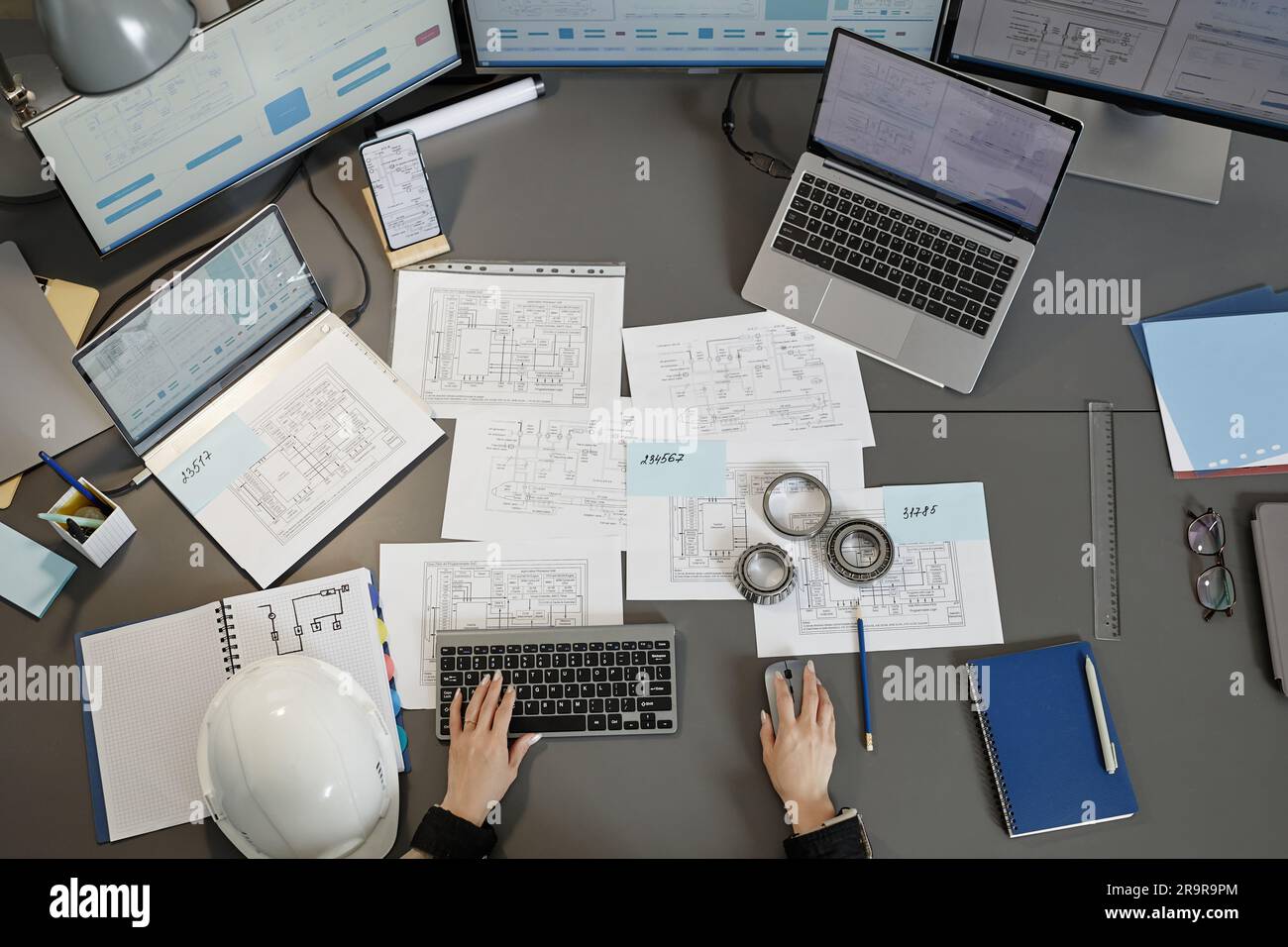 Wide angle top view at engineers workplace with blueprints and plans on ...