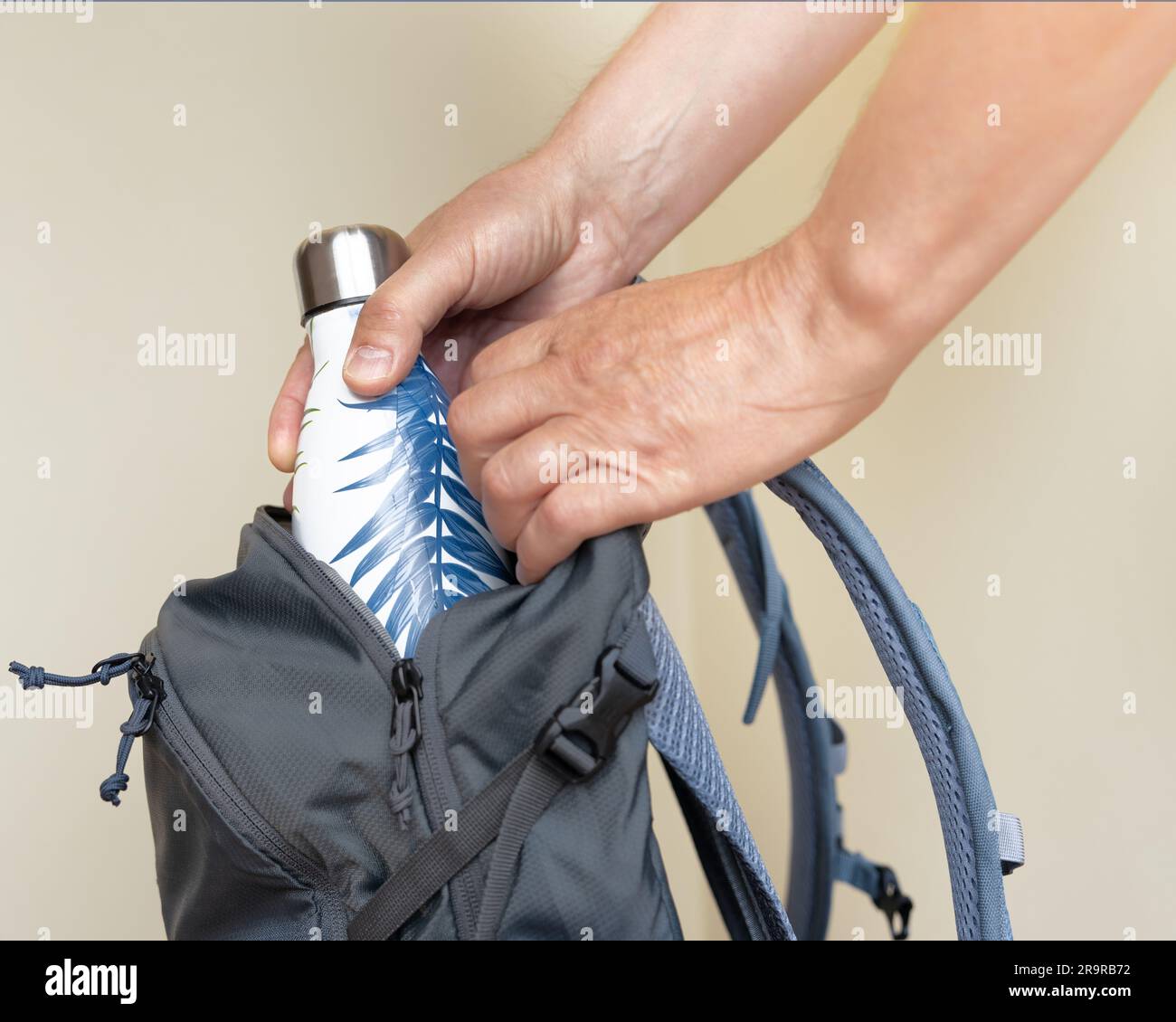 Men's hands put a thermos with a drink in a sports backpack Stock Photo ...