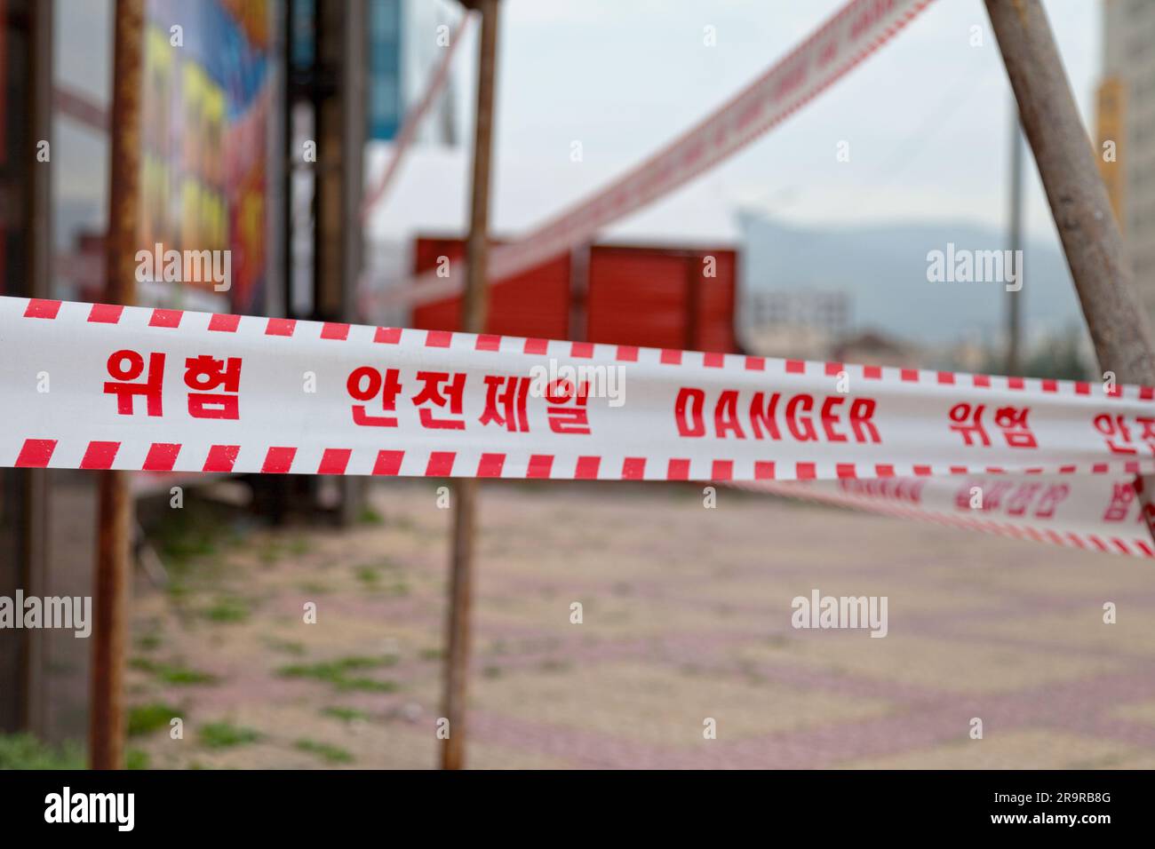 White and red tape with written in korean "Danger - Do not cross Stock ...
