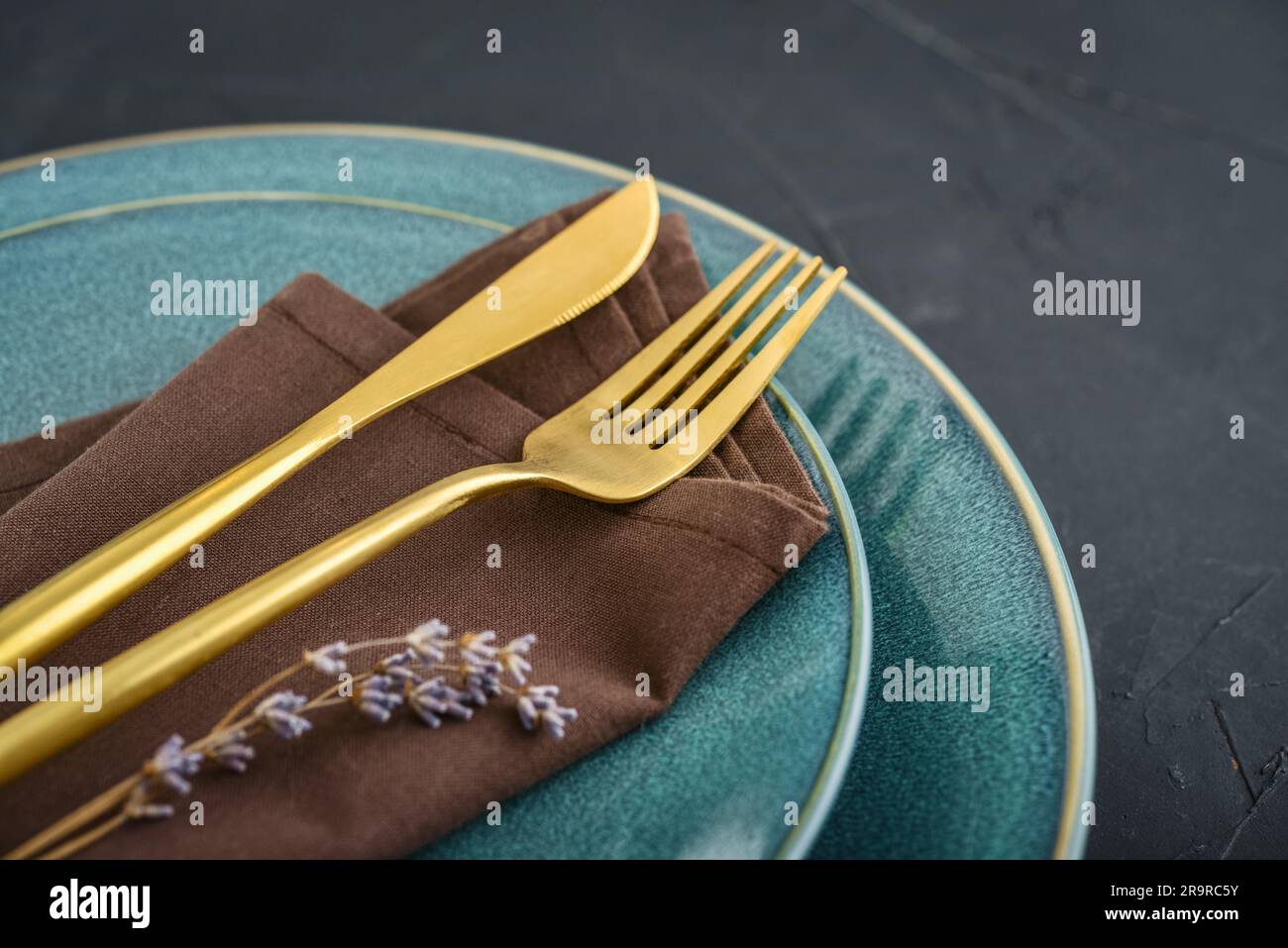 Modern minimal table place setting with blue plates and golden cutlery ...