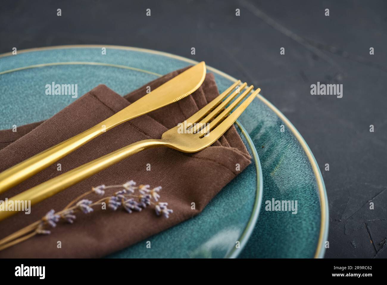Modern minimal table place setting with blue plates and golden cutlery ...