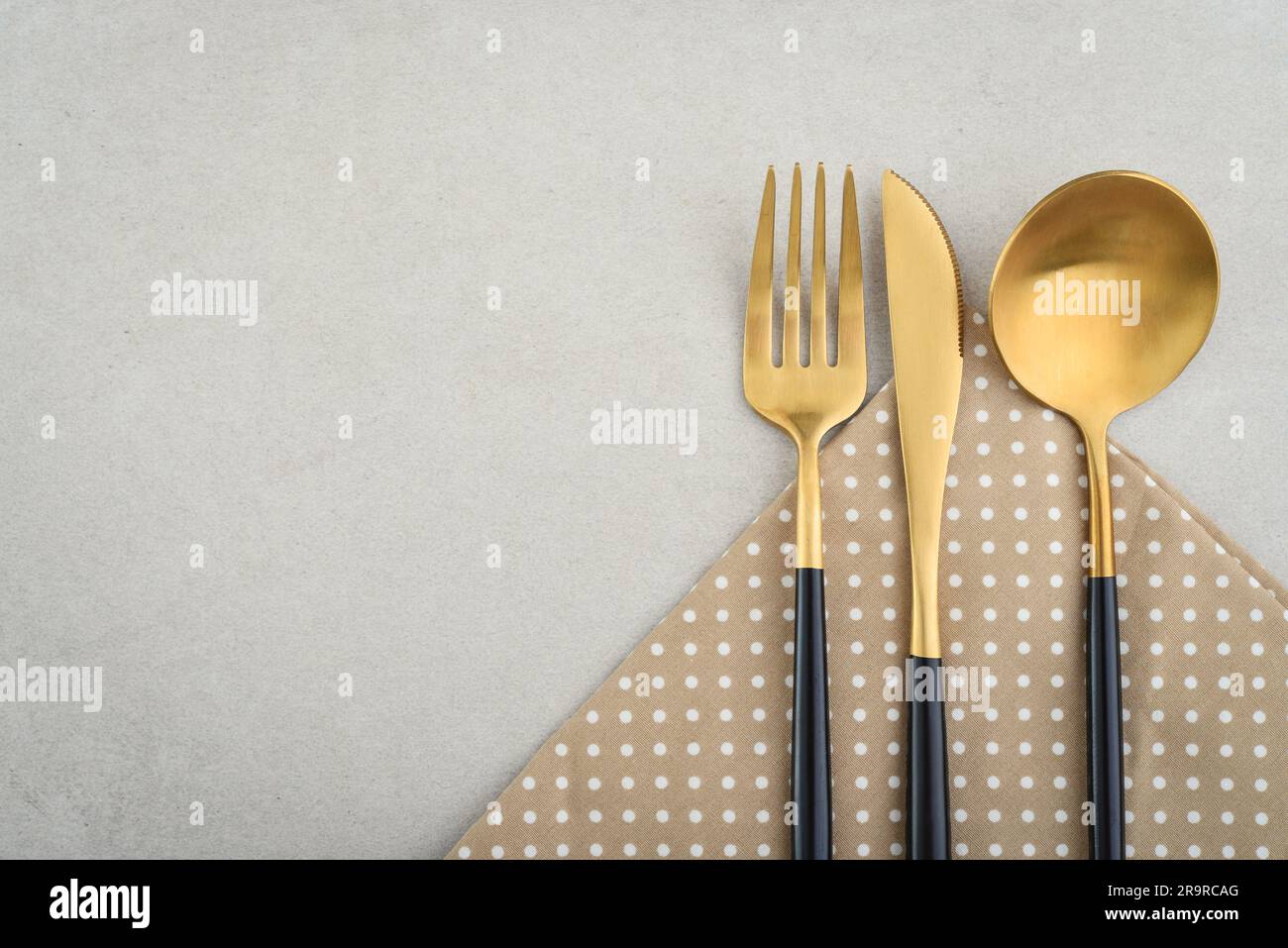 Golden coloured cutlery set with Fork, Knife and Spoon with napkin on ...
