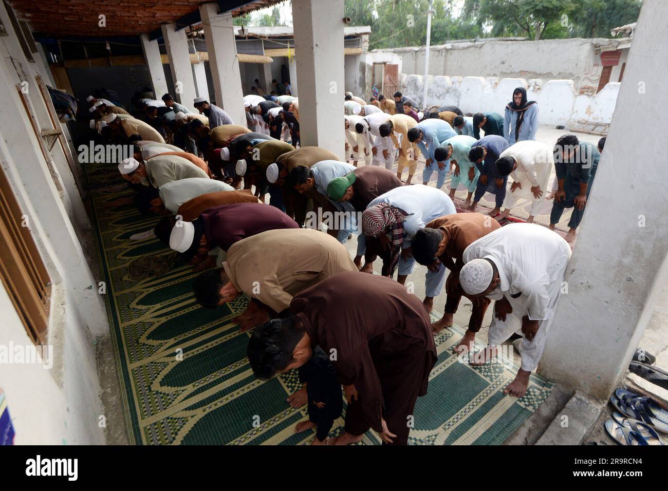 Peshawar, Pakistan. 28th June, 2023. Afghan refugees offer prayers to celebrate Eid al-Adha in ...