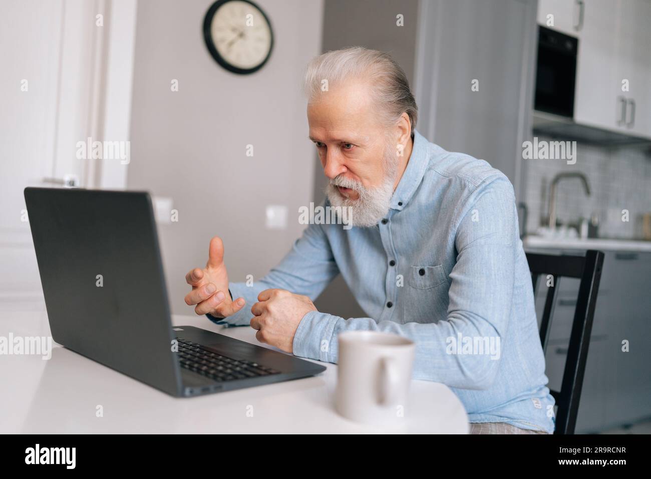 Furious irritated aged gray-haired businessman working from home office ...