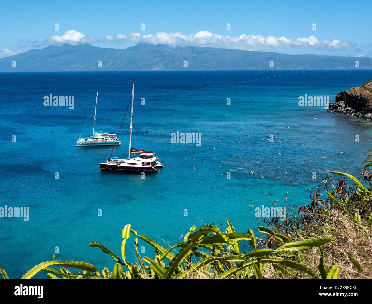 Boats are anchored in a shallow cove that is perfect for snorkeling ...