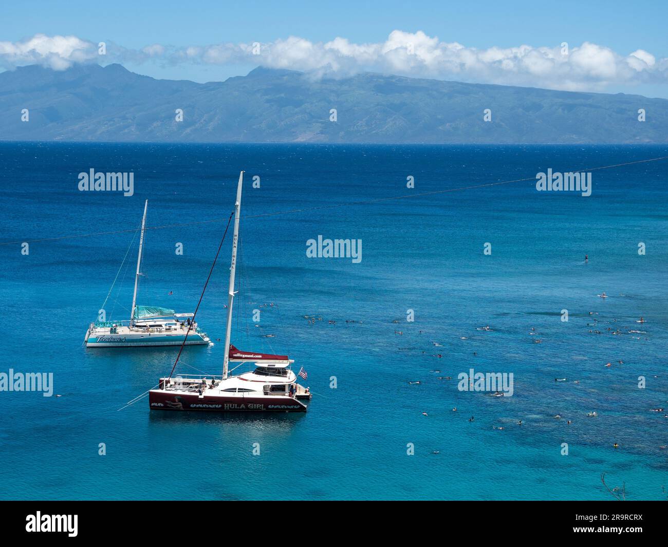 Boats are anchored in a shallow cove that is perfect for snorkeling ...