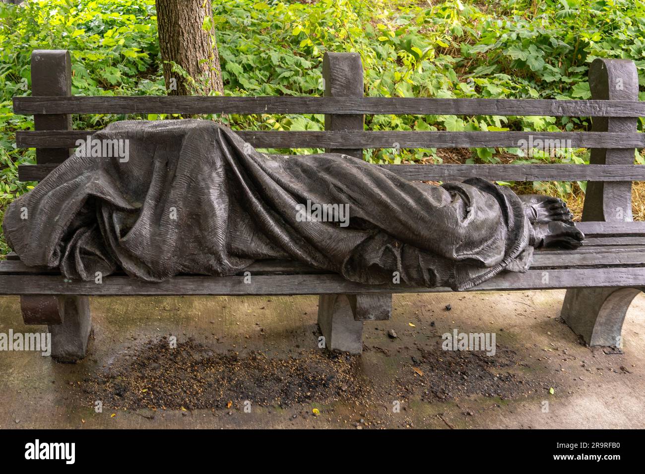Homeless jesus sculpture statue laying down bench hi-res stock ...