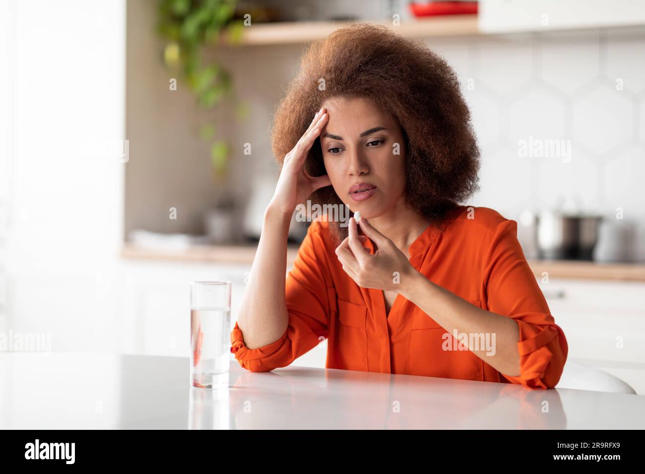 Woman taking pill at desk hi-res stock photography and images - Alamy