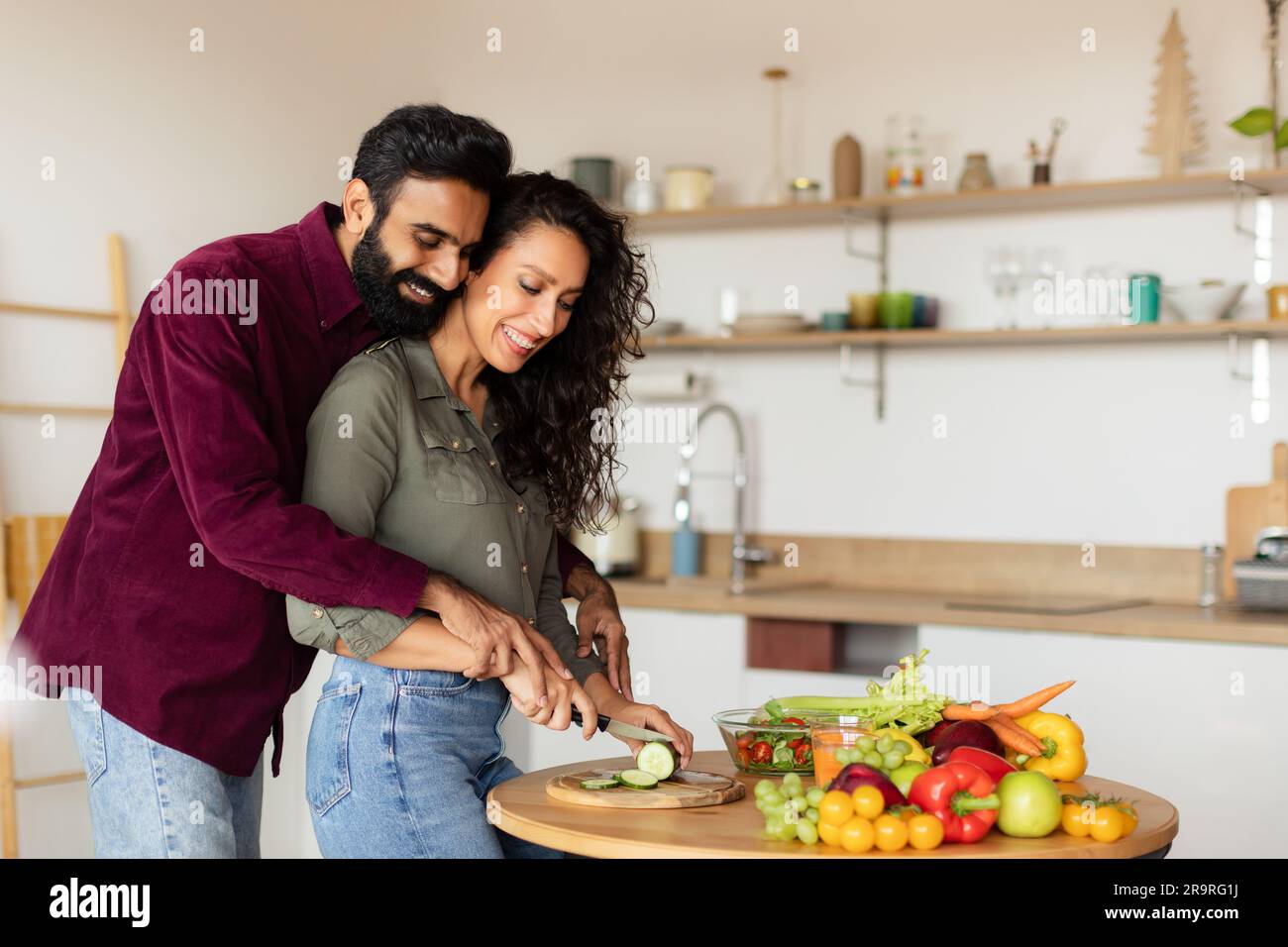 Loving arab spouses cooking together, happy middle eastern man helping ...
