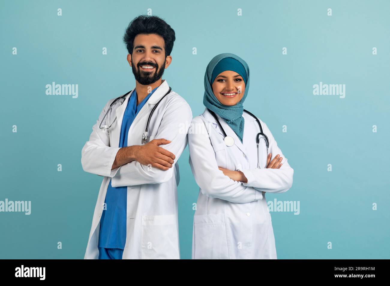 Happy arab doctors man and woman in hijab posing with folded arms Stock ...