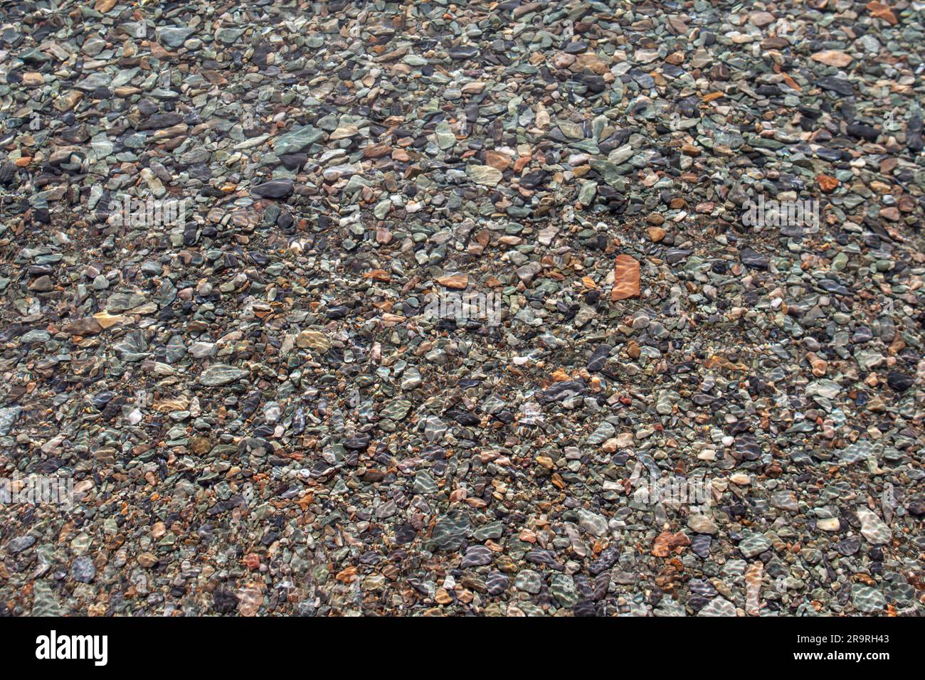 Stones in water background. Wet stones in water of a calm lake ...