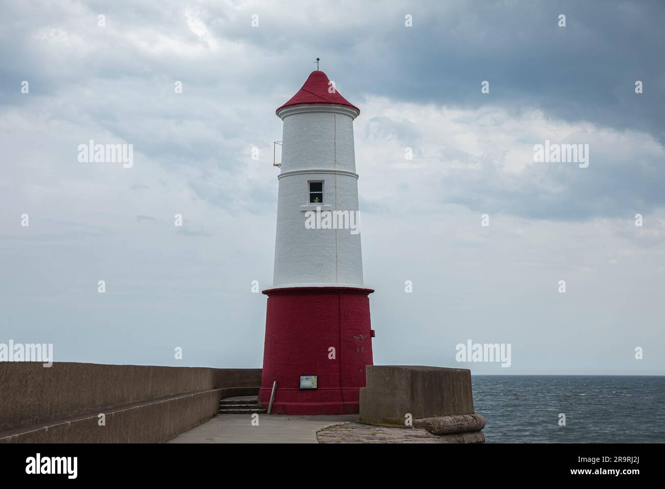 Simple plain red and white painted lighthouse on the harbour at Berwick ...