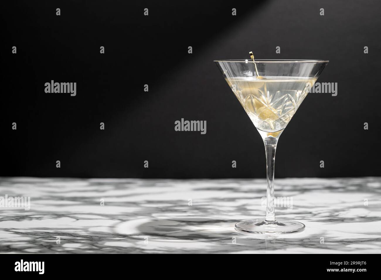 A crystal-clear glass filled with a golden liquid positioned atop a ...