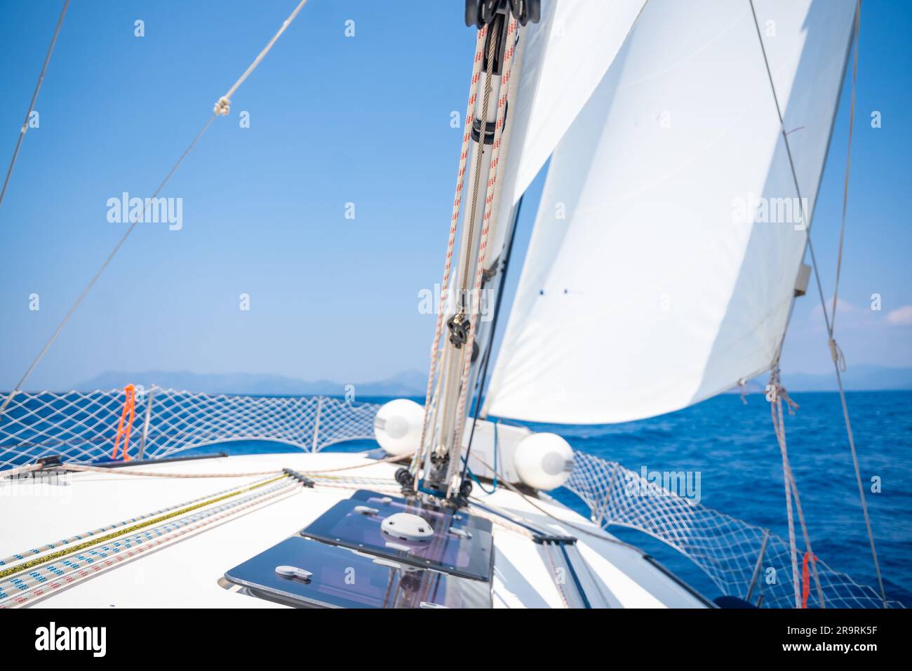 Yacht sailing in an open sea. Close-up view of the deck, mast and sails ...