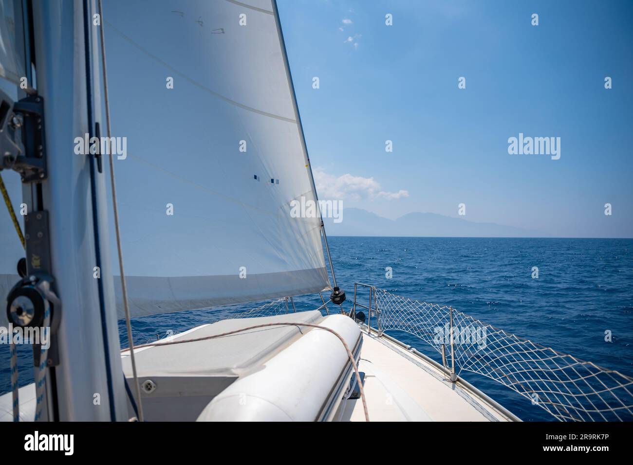 Yacht sailing in an open sea. Close-up view of the deck, mast and sails ...