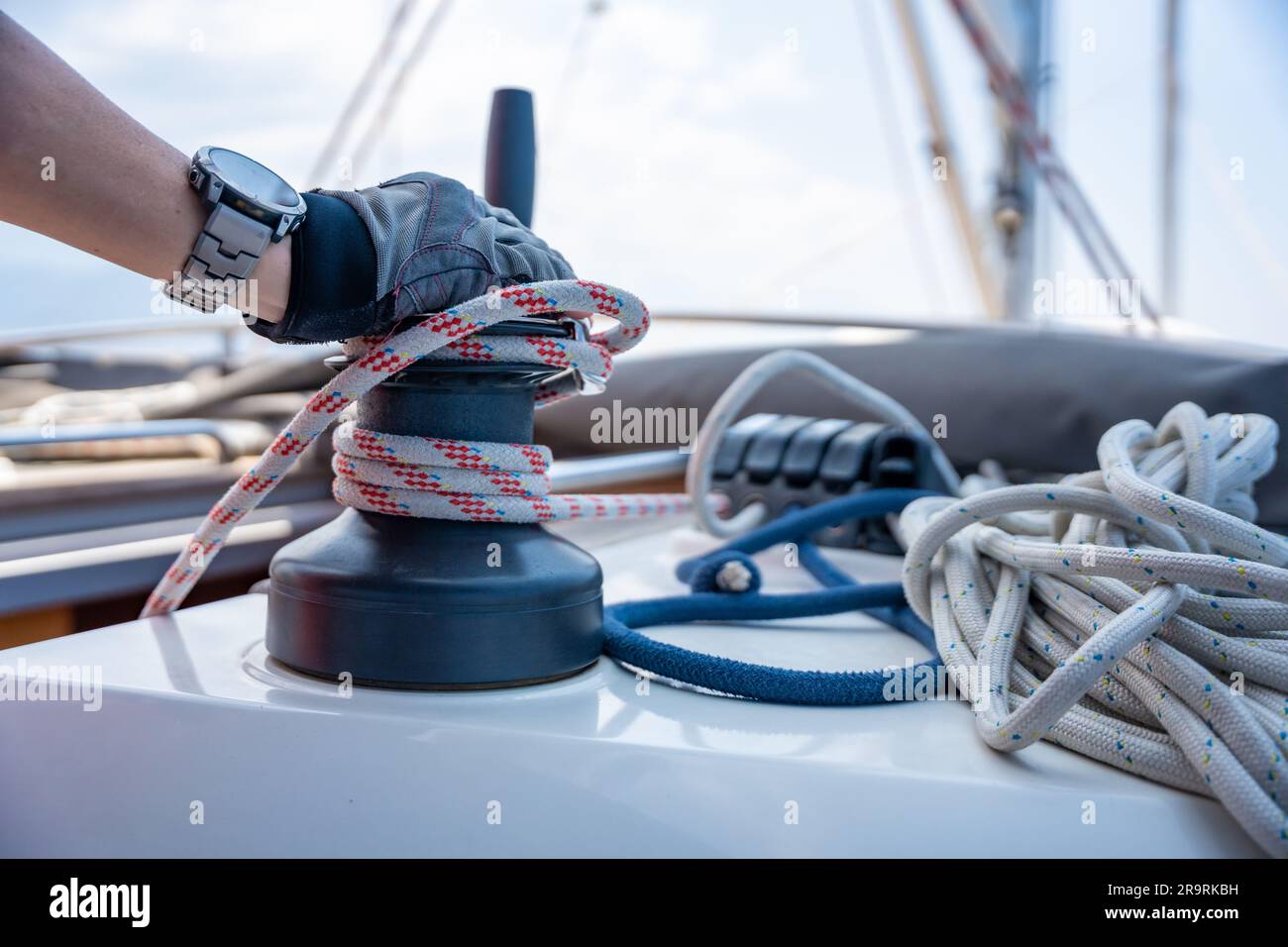 Mans hand pulling winch rope on sailing boat Stock Photo - Alamy