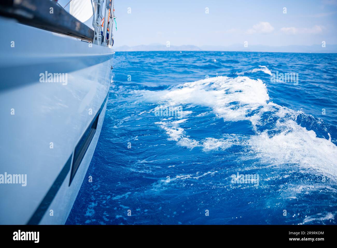 Yacht sailing in an open sea. Close-up view of side of the boat. Clear ...