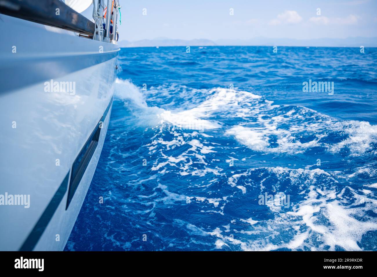 Yacht sailing in an open sea. Close-up view of side of the boat. Clear ...