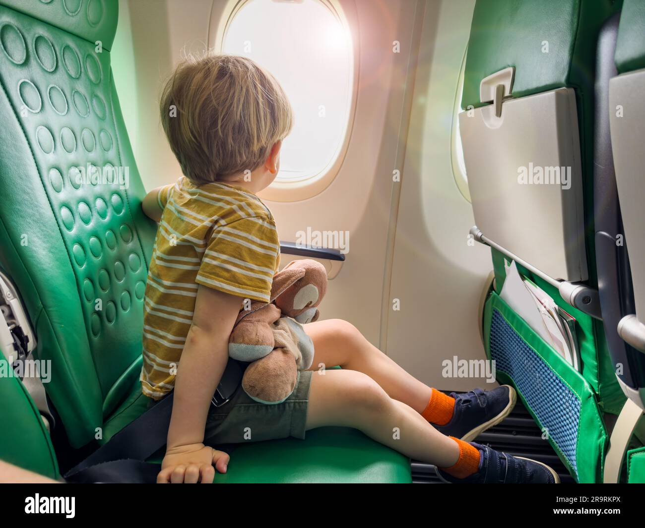 Little boy sit near window in the plane looking at porthole Stock Photo ...