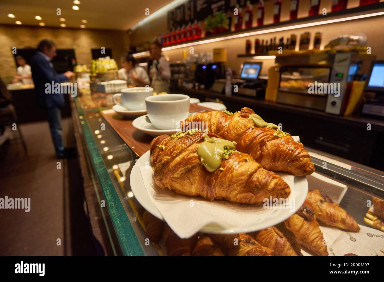 Assortment of freshly baked croissants for sale on counter of shop ...
