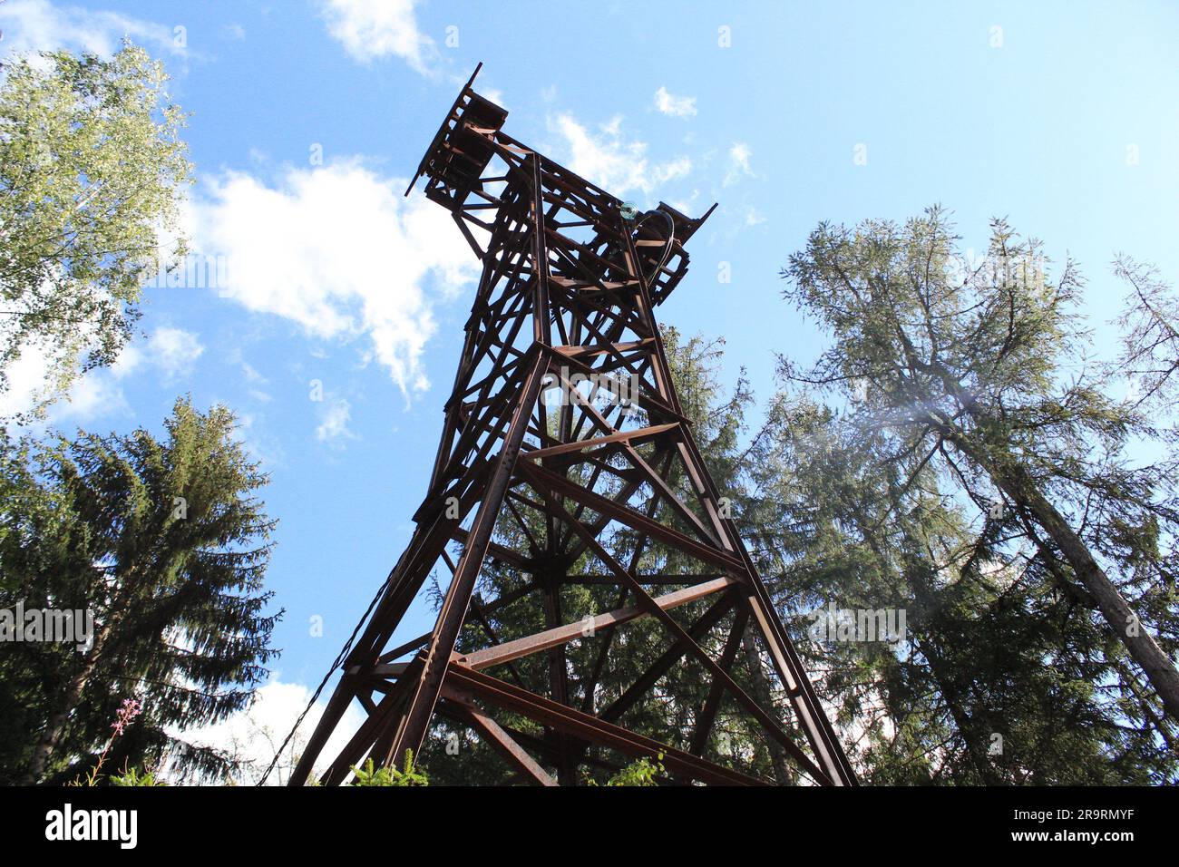 An aerial shot of a forest in Europe, with a tall fire lookout tower ...