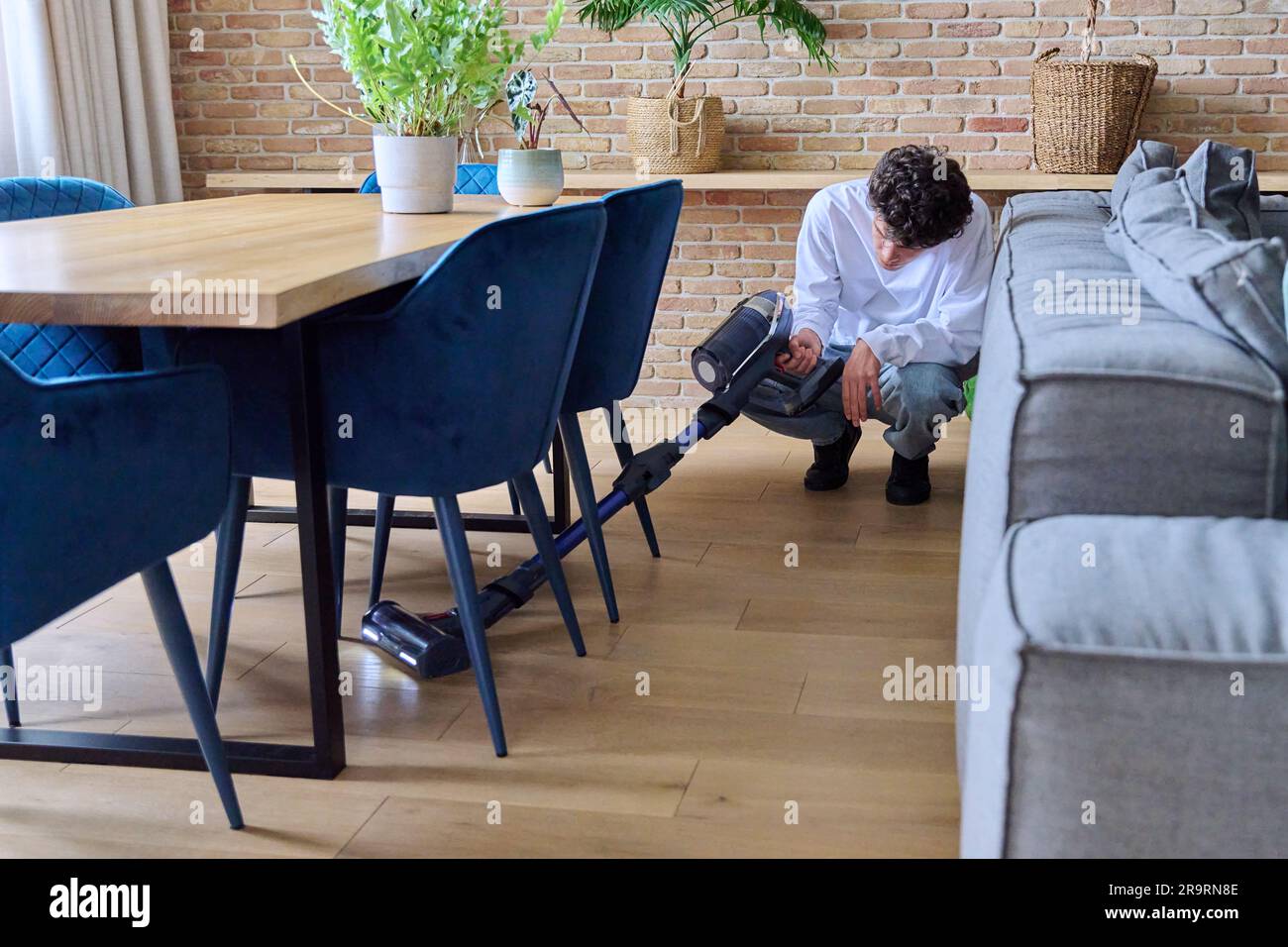 Young guy doing vacuuming, at home in the living room Stock Photo - Alamy