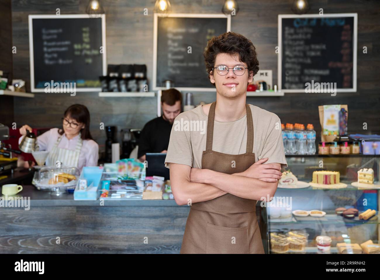 Coffee shop workers, a young guy in an apron in focus Stock Photo - Alamy
